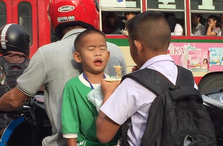 LOOK: Photo of Thai student feeding kid brother on motorcycle ride goes ...